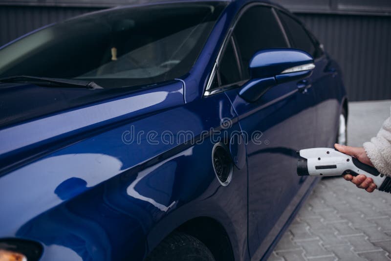 Human Hand is Holding Electric Car Charging Connect To Electric Car ...