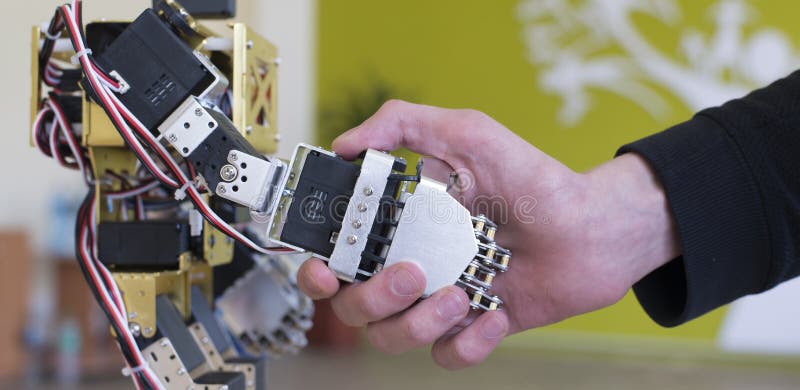 Human Hand Holding a Robot Hand with a Handshake Stock Image - Image of ...