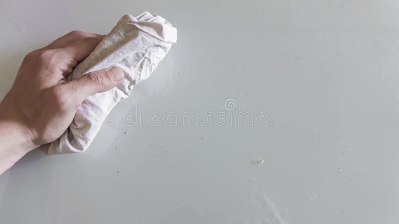 Human Hand Holding a White Piece of Fabric and Wiping the White Surface ...