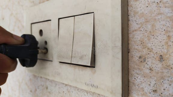 A Human Hand Inserting a Plug in a Socket of a Switch Stock Photo ...
