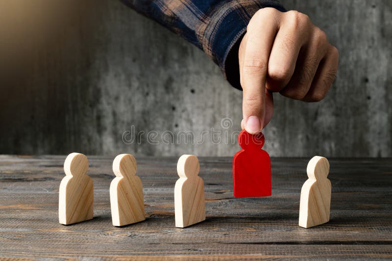 A Human Hand Put One Wooden Figure To the Row of Wooden Figures Stock ...