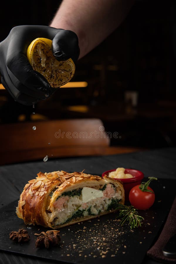 Human Hand Squeezing a Lemon on French Pie with Salmon and Cheese Stock ...