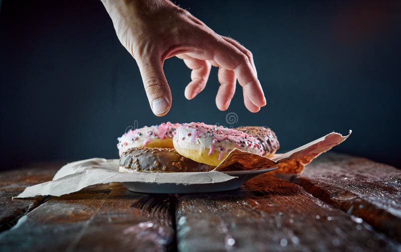 Human Hand Takes a Sweet Fried Donut from the Wood Table Stock Photo ...