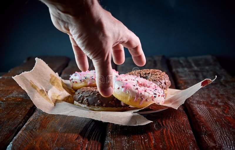 Human Hand Takes a Sweet Fried Donut from the Wood Table Stock Photo ...