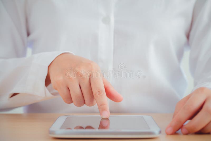 Human Hand Touching the Screen of a Tablet Which is Placed on the ...