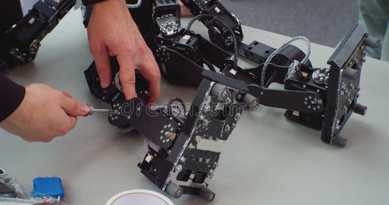 Human Hands are Engaged in Repairing a Broken Robot with a Screwdriver ...