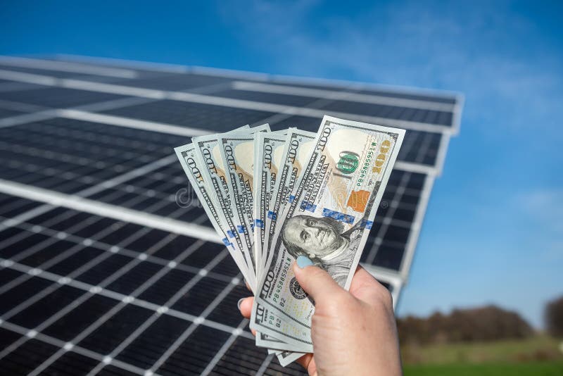 Human Hands with a Large Amount of Dollars in Front of Solar Panels ...
