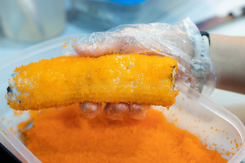 Human Hands Making Sushi Rice Rolls on a Sushi Mat. it is a Popular ...