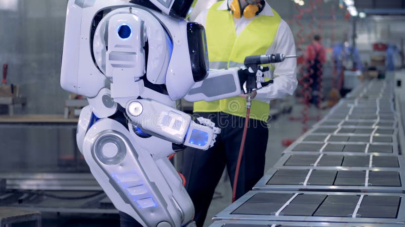 Human Factory Worker and a Robot are Walking Together in Factory ...