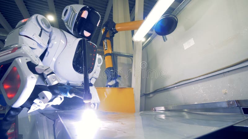 Metal Plate is Being Welded by a Cyborg in a Modern Factory Facility ...