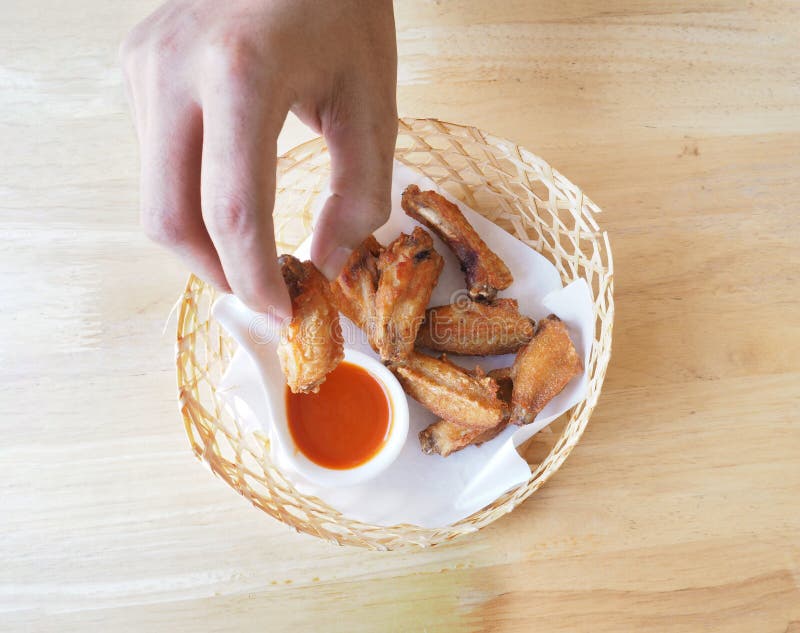 Human`s Hand Pick Fried Chicken Up and Dip in Sauce. Stock Photo ...