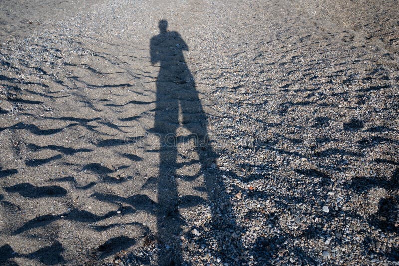 Human shadow on the sand stock image. Image of standing - 228862057