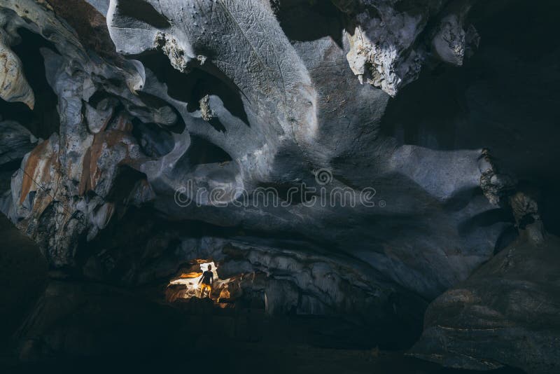 Human Silhouette Stands Inside the Cave with Light Coming from the ...