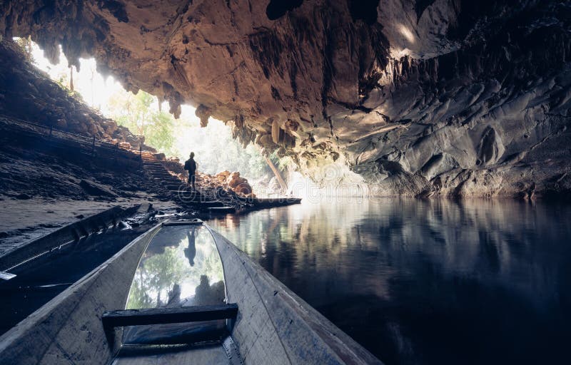 Human Silhouette Stands Inside Water Cave with Torch in Hand in Konglor ...