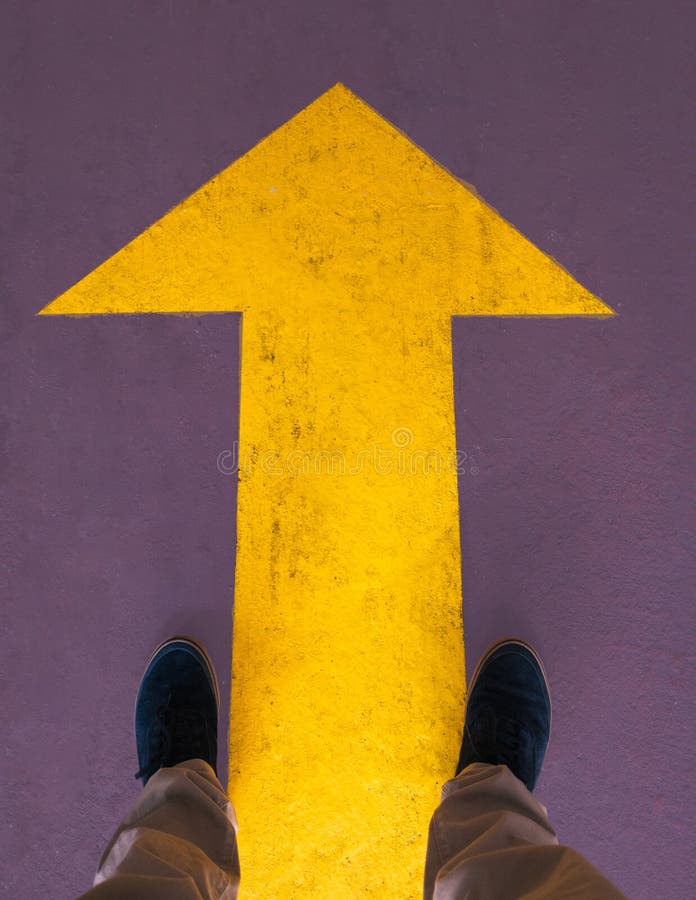 Human Standing on a Yellow Arrow Sign Stock Image - Image of direction ...