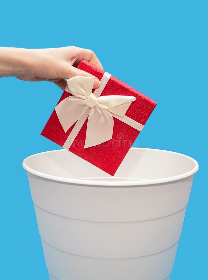 Human Throws a Gift Box into a Trash Can on a Blue Background Stock ...
