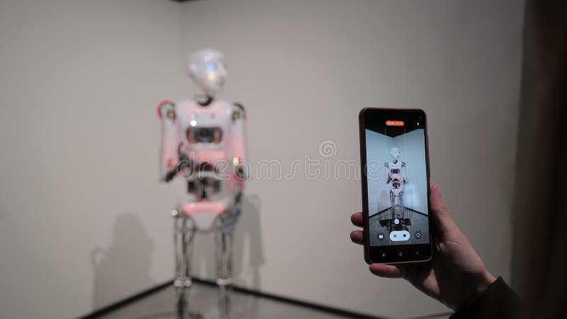A Humanoid Robot is Presented at the Exhibition. Shooting with a Phone ...