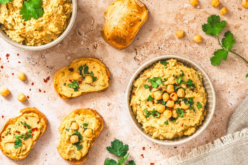 Hummus, Chickpea Puree in a Bowl and on Toasted Bread Slices Stock ...