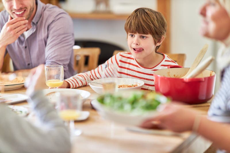 Hungry Boy at the Dining Table with the Family Stock Photo - Image of ...