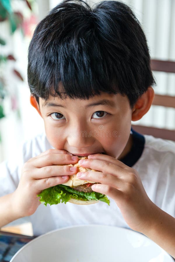 Hungry Boy Eating Burger stock photo. Image of appetizer - 43350660
