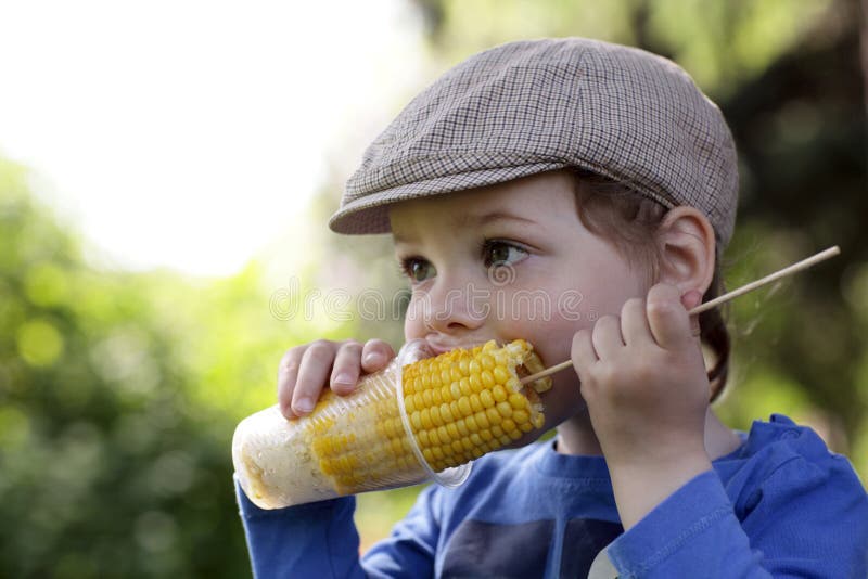 Hungry boy eating corn stock photo. Image of expression - 42367950