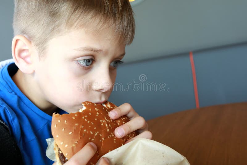 Hungry kid has burger stock photo. Image of junk, male - 229560036