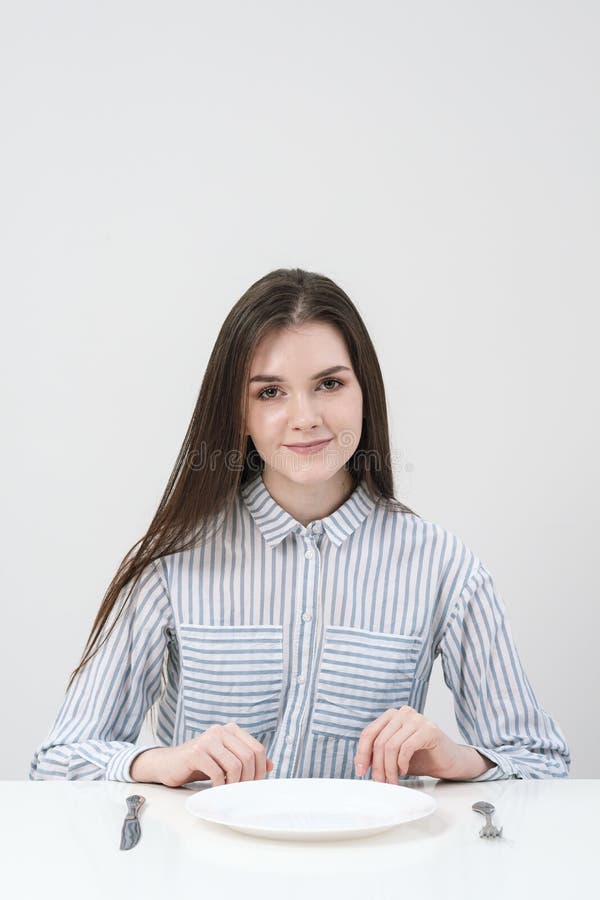 Hungry Thin Girl Sitting at the Table in Front of an Empty Plate with a ...