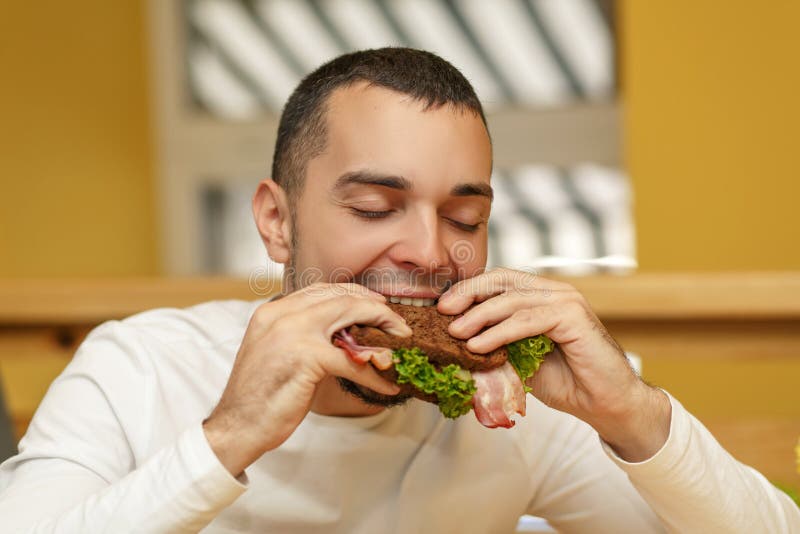 Hungry Young Man in Restaurant Eat Sandwich. Stock Image - Image of ...