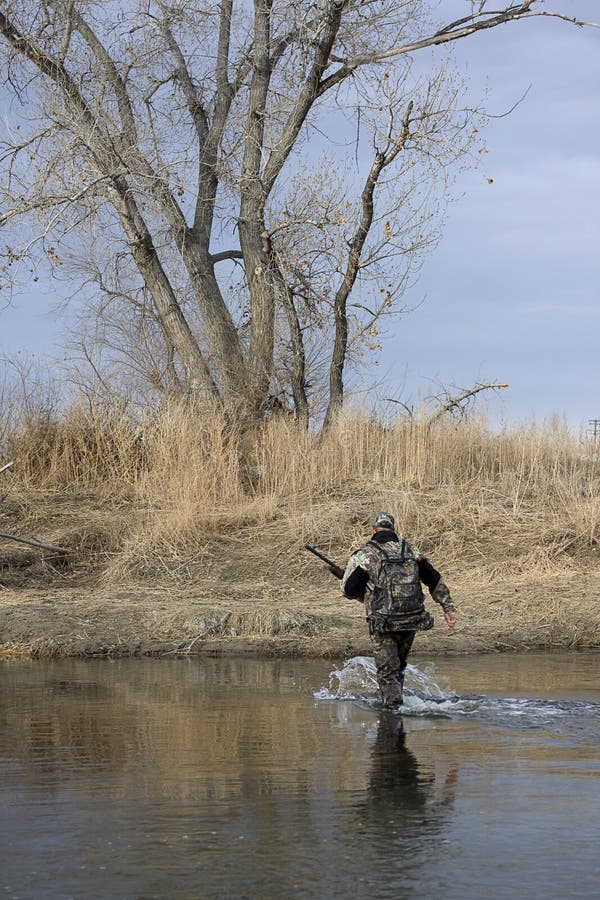 Hunter crossing a river stock photo. Image of wading, trapper - 4205932