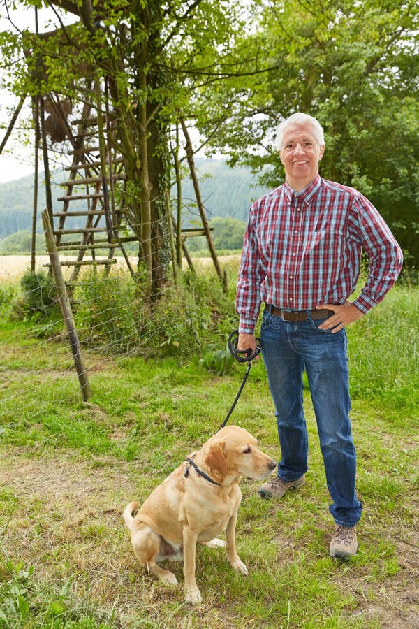Hunter with Dog in Front of Tree Stand Stock Photo - Image of tree ...