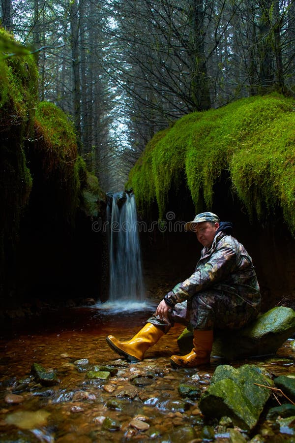 A Hunter in the Forest during the Day with Moss and Grass. Stock Photo ...