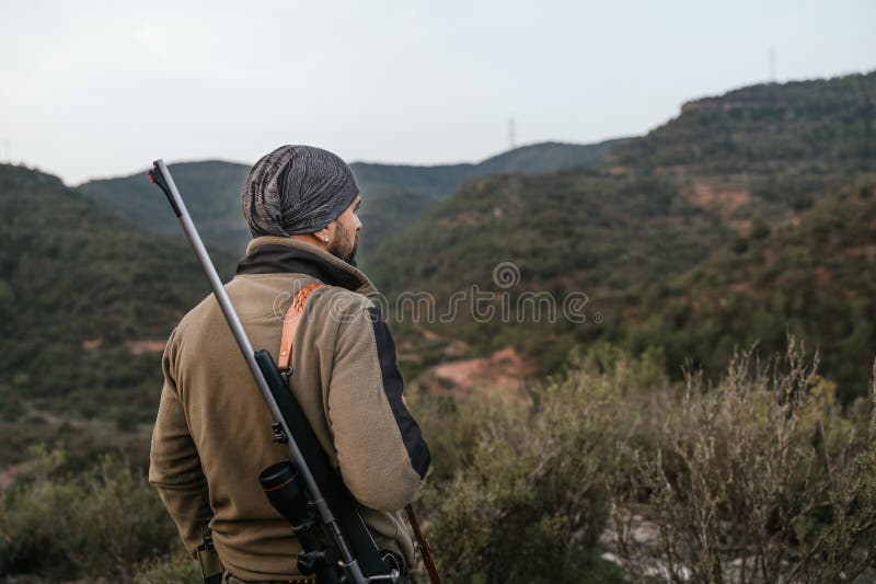 Hunter Looking at the Horizon with Rifle on Shoulder Stock Photo ...