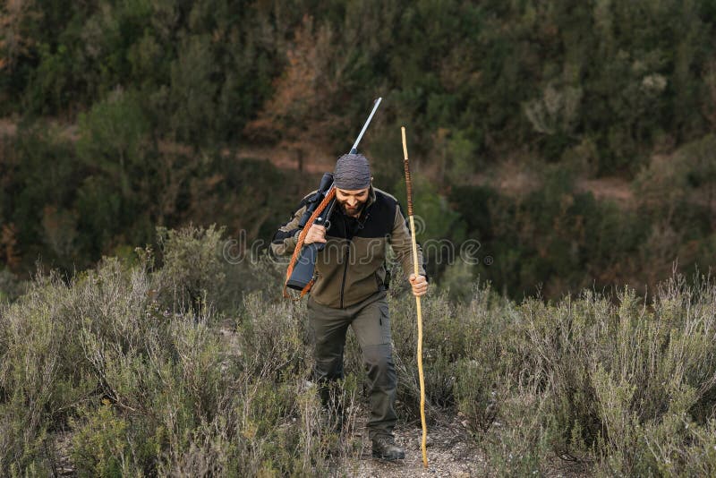 Hunter Walking on a Path in the Forest Carrying a Rifle Stock Image ...