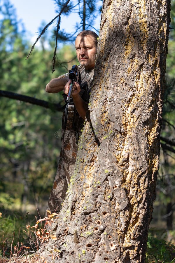 Hunting. Hunter with Rifle Behind Tree with Shadow on Face. Stock Photo ...