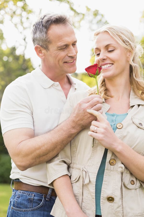 Husband Offering a Rose To Wife Stock Image - Image of casual, green ...