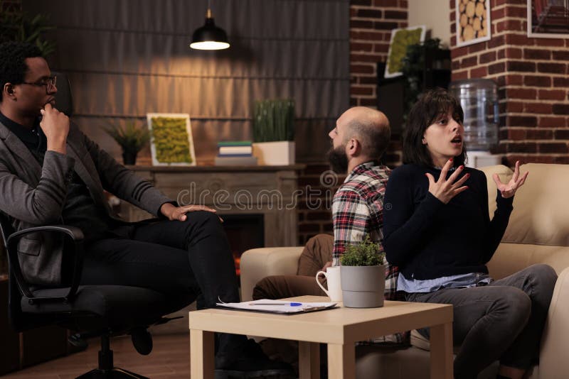 Husband And Wife Fighting At Couple Therapy Session With Counselor