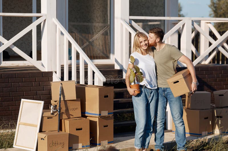 Husband and Wife Standing in Front of New Buying Home with Boxes Stock ...