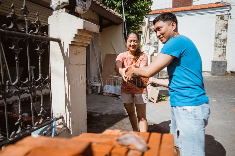 A Husband and Wife Work Together To Move Bricks To Build Stock Image ...