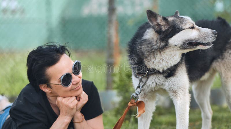 A Husky Owner Poses on the Grass on a Warm Day with Her Doggie. Stock ...