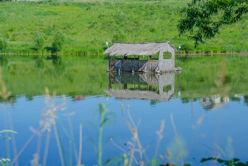 Hut on the pond stock photo. Image of brink, blue, green - 58442024