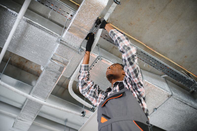 African American Hvac Technician Installing Air Duct, Ensuring Proper ...