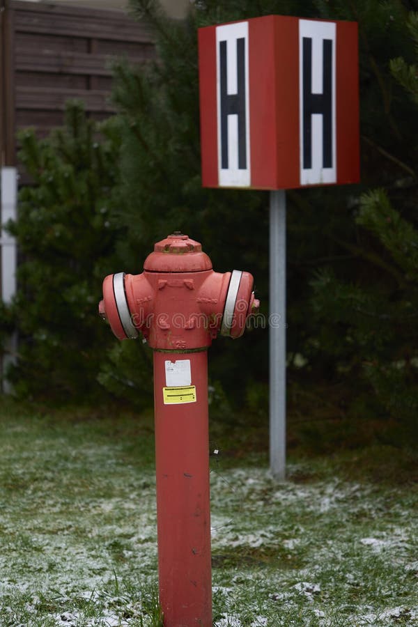 The Hydrant Marker and Fire Hydrant are Both Located within a Lush Area ...