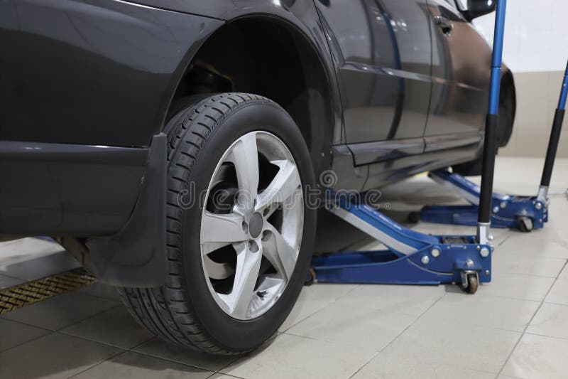 Hydraulic Floor Jacks Under a Black Car in a Car Stock Image - Image of ...