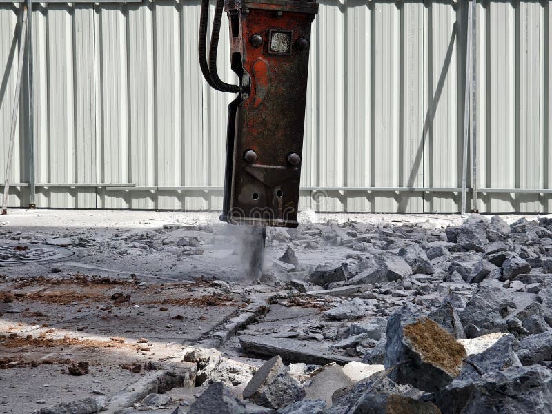 A Hydraulic Hammer Breaking Concrete at a Construction Site Stock Image ...