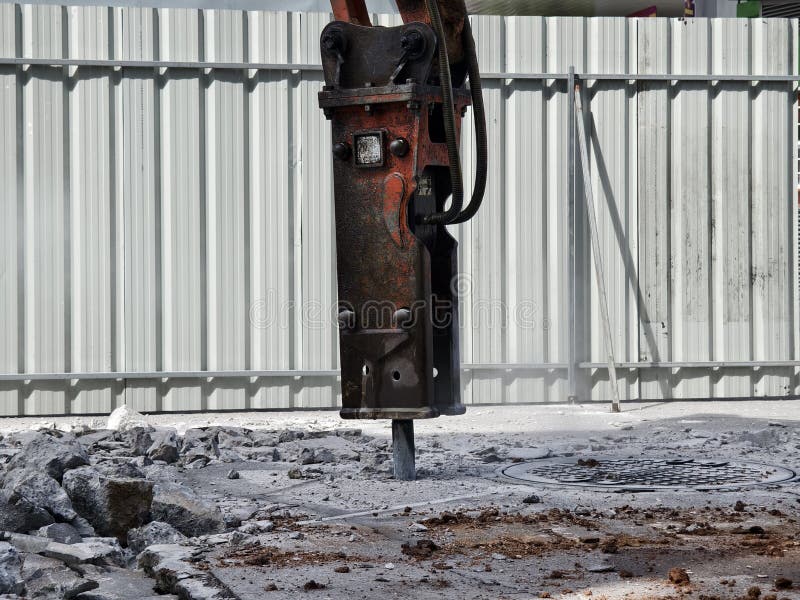 A Hydraulic Hammer Breaking Concrete at a Construction Site Stock Photo ...