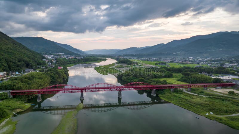 Hyperlapse: Light Traffic Over Arched Red Bridge Over River at Dusk ...
