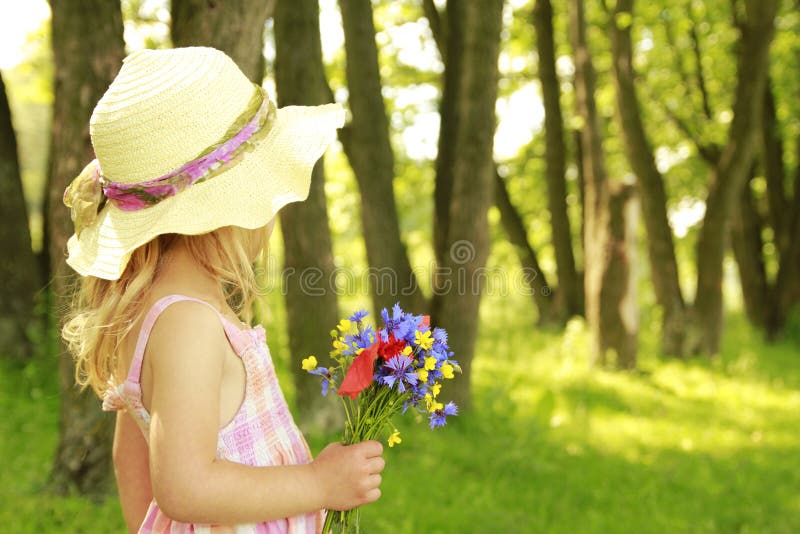 Härlig Liten Flicka Med En Bukett Av Blommor I Natur Fotografering För