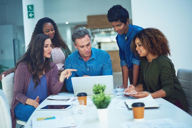 I Can Work My Magic on that. a Group of Designers Gathering Around a ...