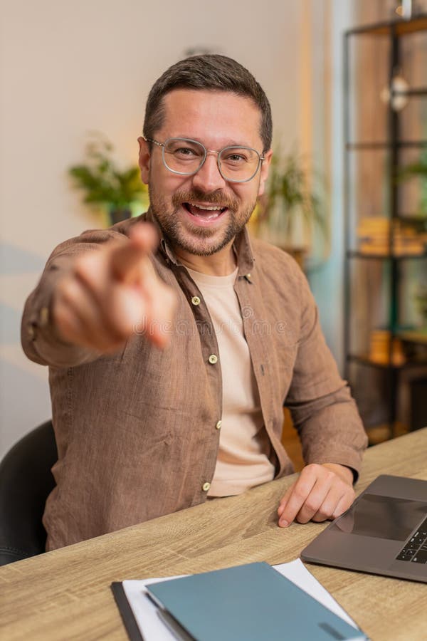 Excited Businessman at Home Office Table Working on Laptop Pointing To ...