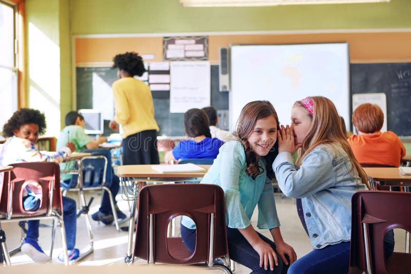 I Know Something You Dont Know...a Student Whispering in a Friends Ear ...